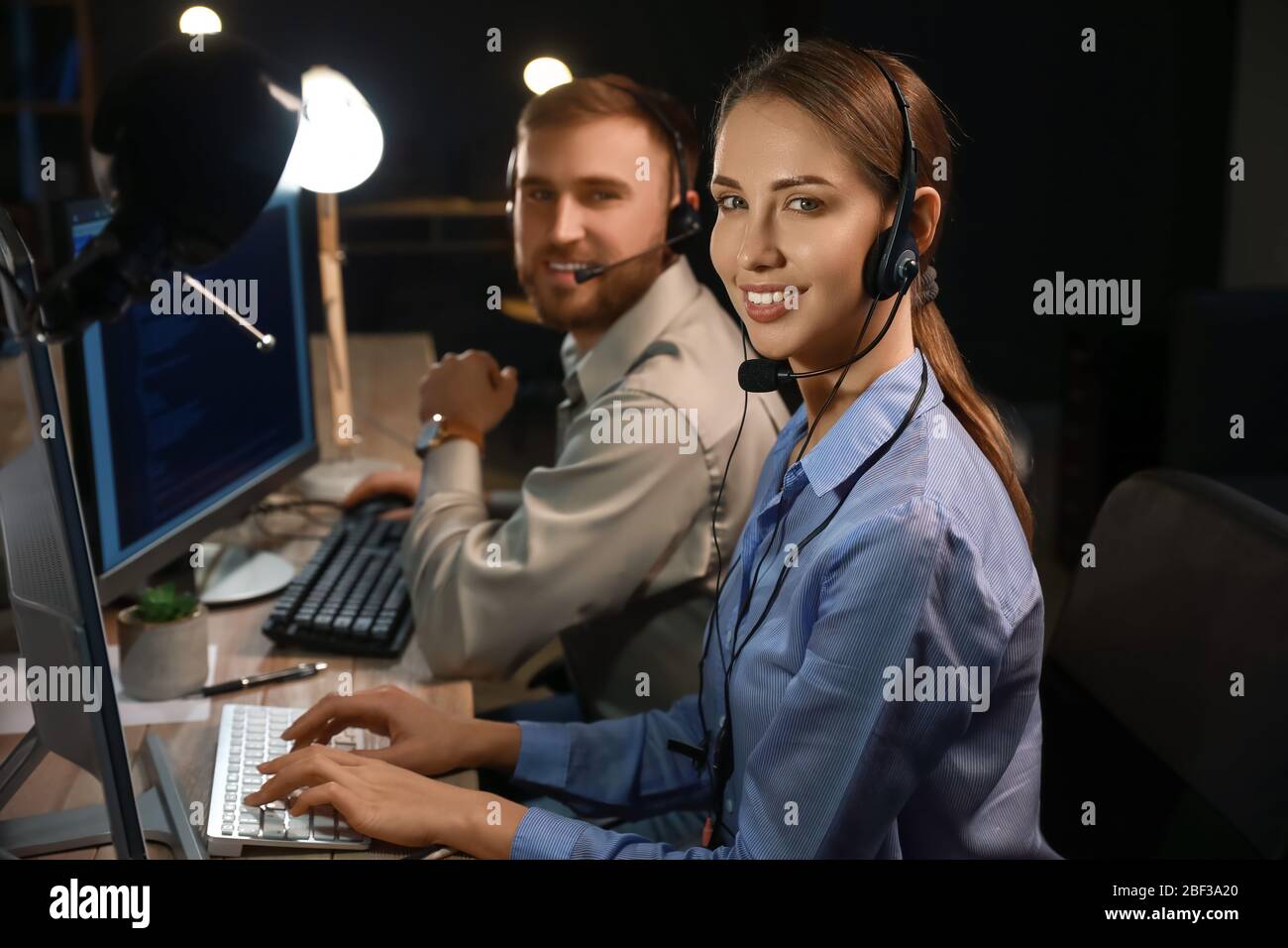 Technical support agents working in office at night Stock Photo - Alamy
