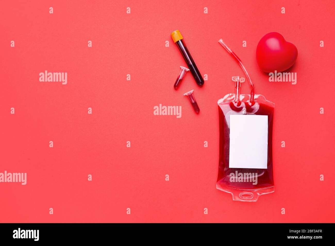 Blood pack for transfusion, test tubes and heart on color background ...