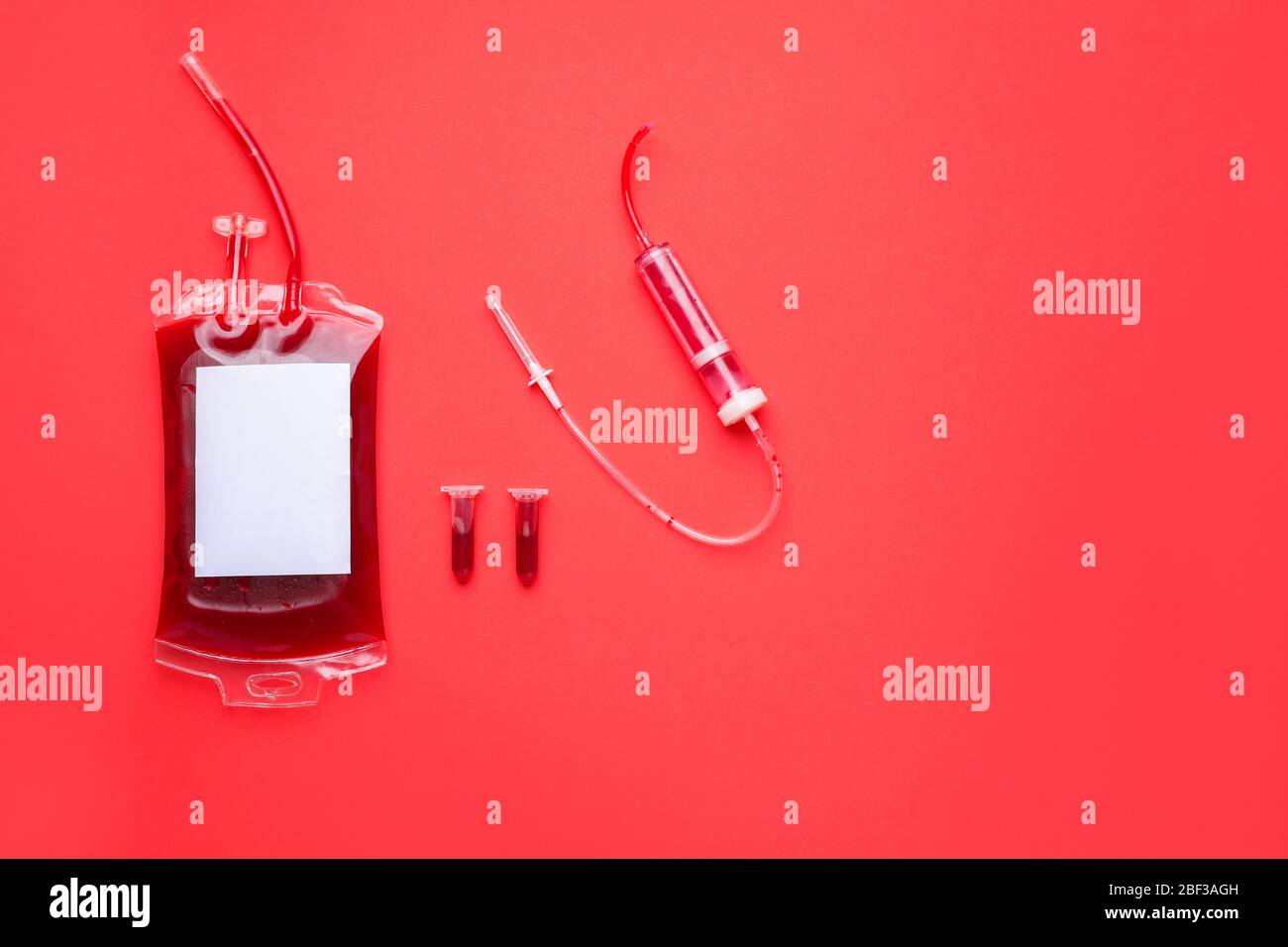 Blood pack for transfusion, test tubes and catheter on color background ...