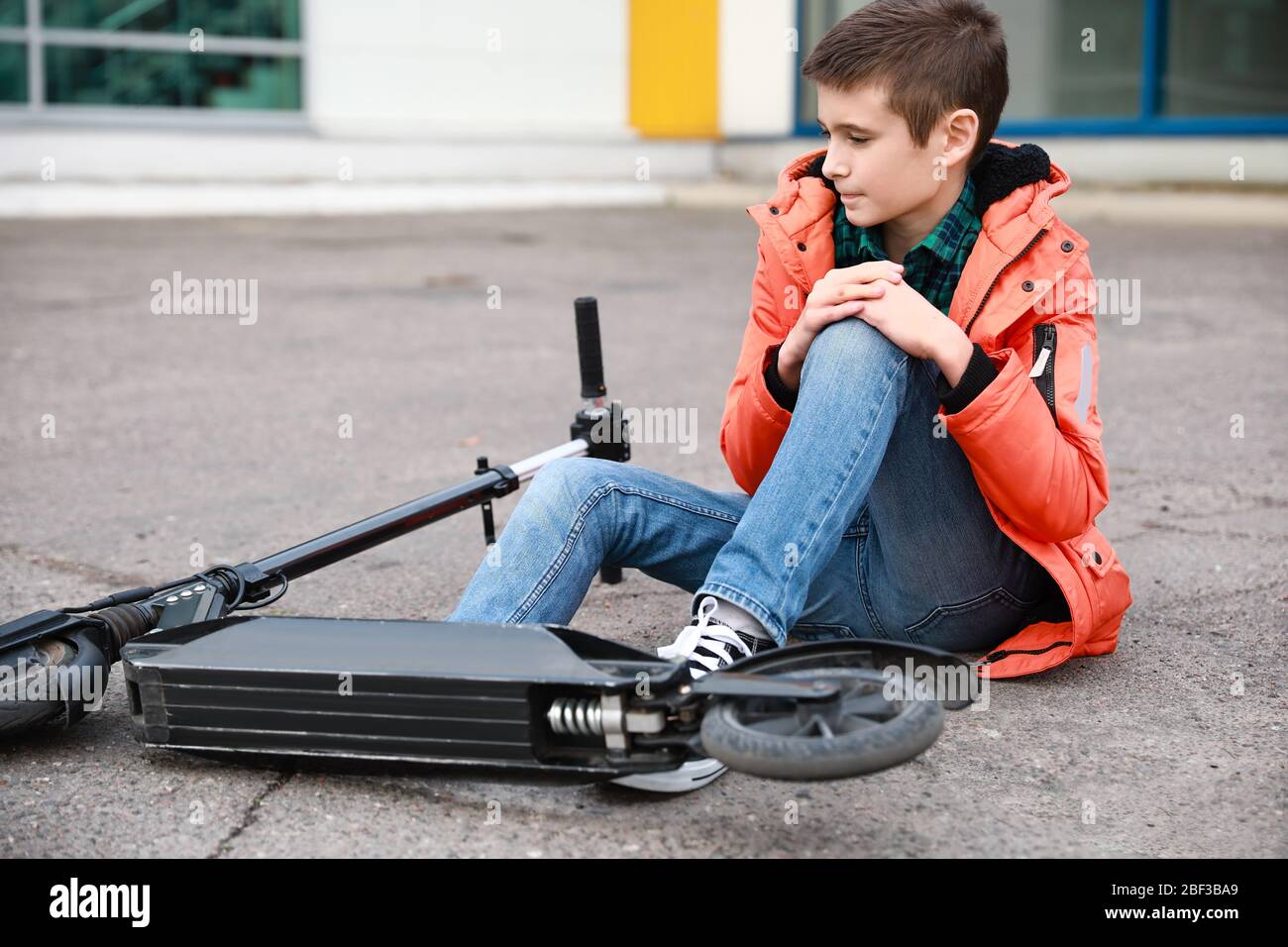 Teenage boy fallen off his kick scooter outdoors Stock Photo - Alamy