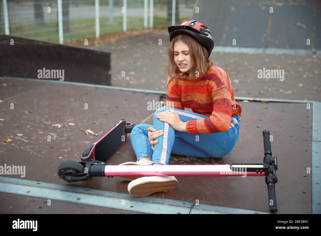 Teenage girl fallen off her kick scooter outdoors Stock Photo - Alamy