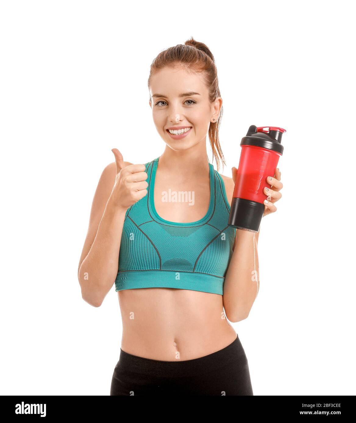 Sporty young woman with protein shake showing thumb-up on white ...