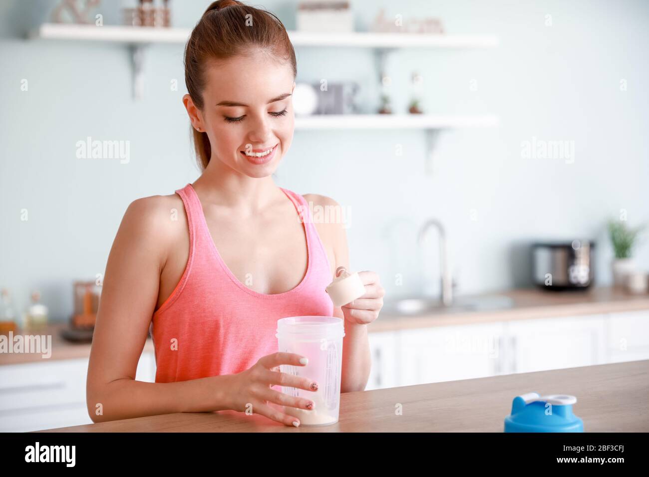 Sporty young woman making protein shake at home Stock Photo - Alamy