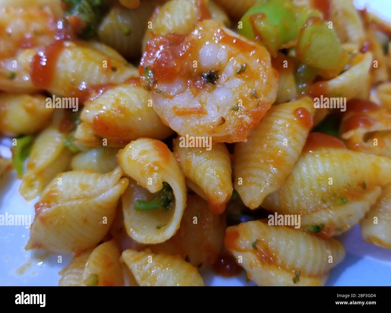 Pasta shells in red sauce with broccoli and shrimp Stock Photo - Alamy