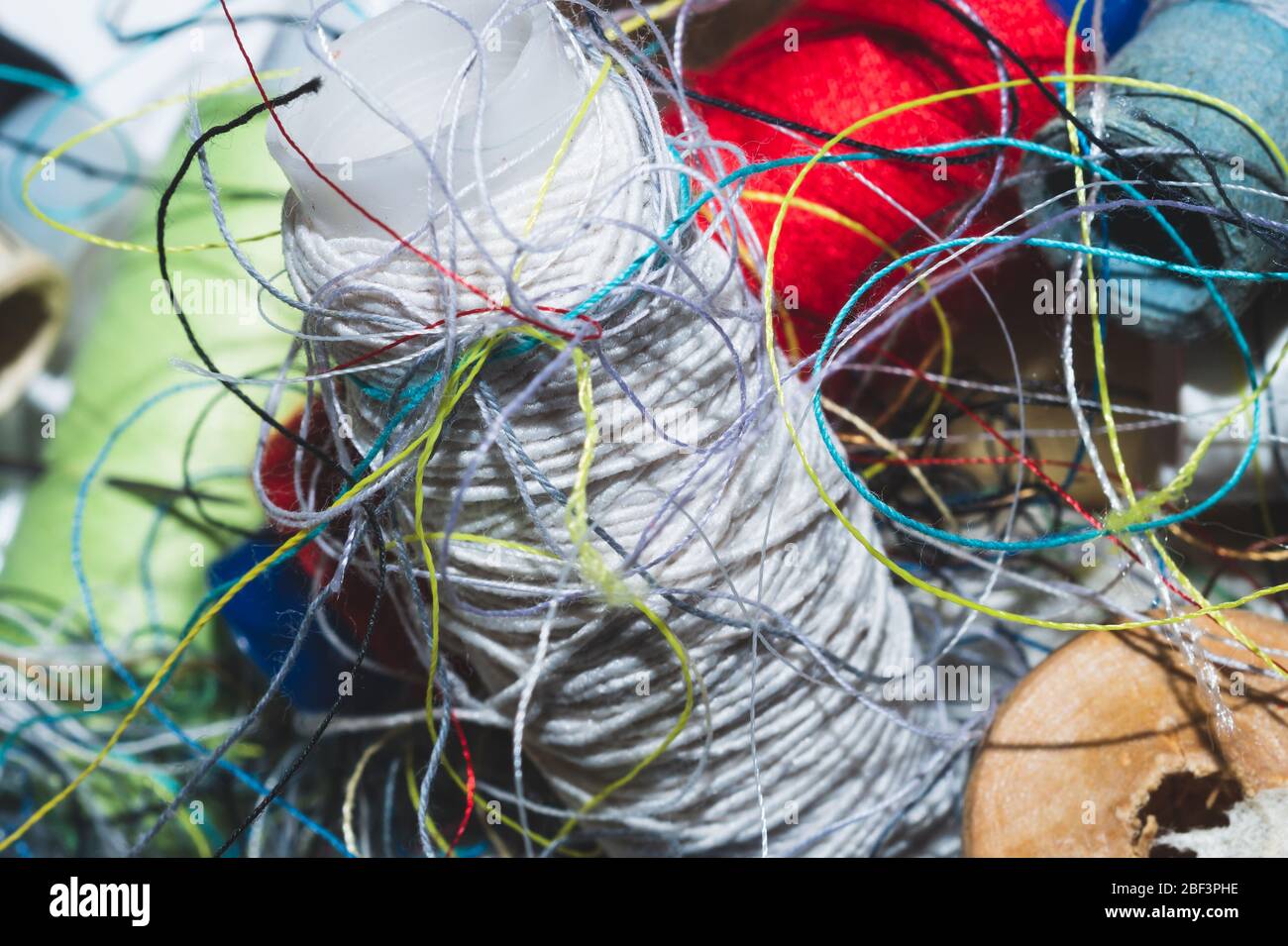 Tangled threads for sewing. different spools of thread Stock Photo - Alamy