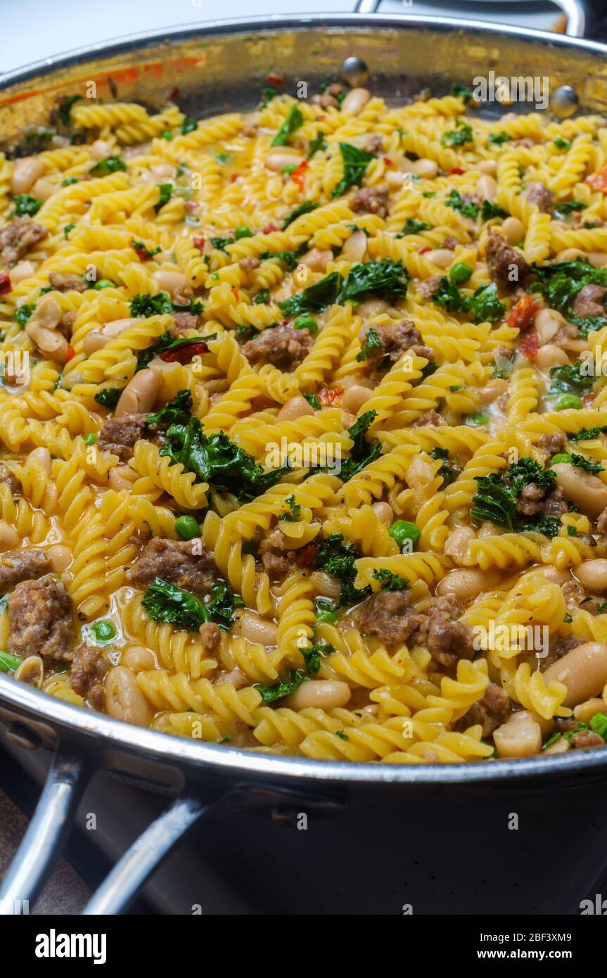 Cooking Italian kale sausage rotini pasta in white wine butter garlic ...