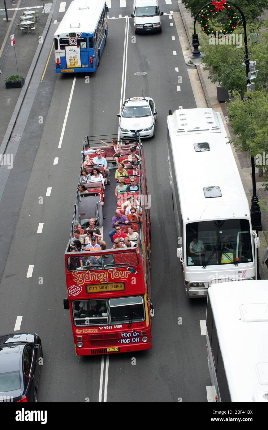 VIEW OVER TRAFFIC AND A SYDNEY OPEN TOP DOUBLE DECKER RED BUS FULL WITH ...