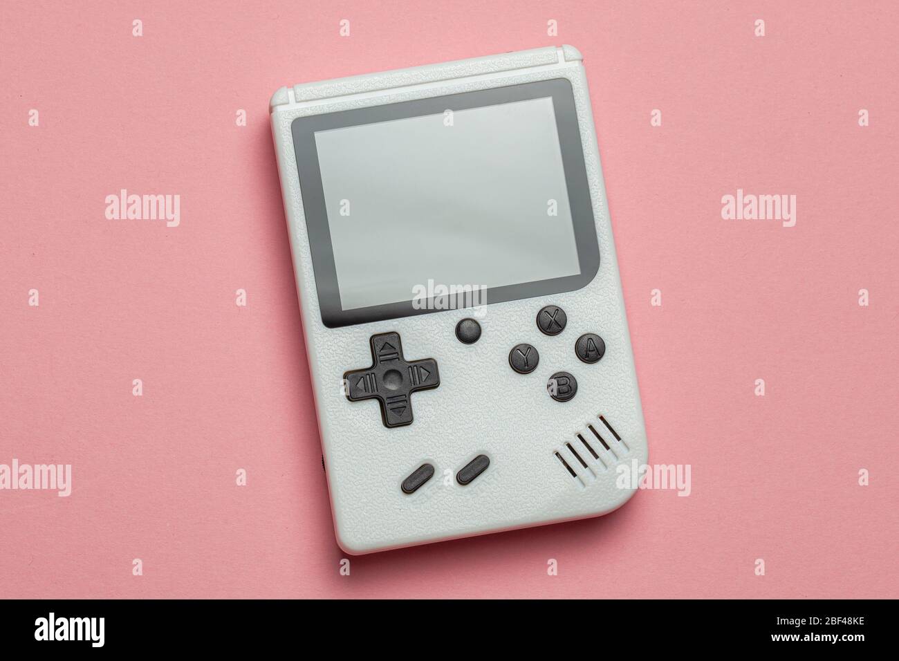 Old game console. Gamepad is white on a pink background. Copy space for ...