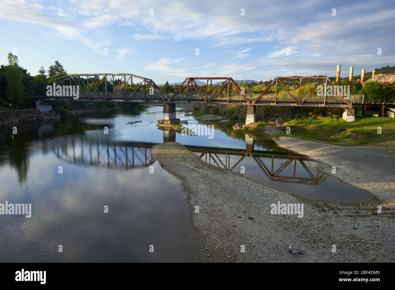 Wide view of rusty abandoned steel truss railroad bridge over the ...