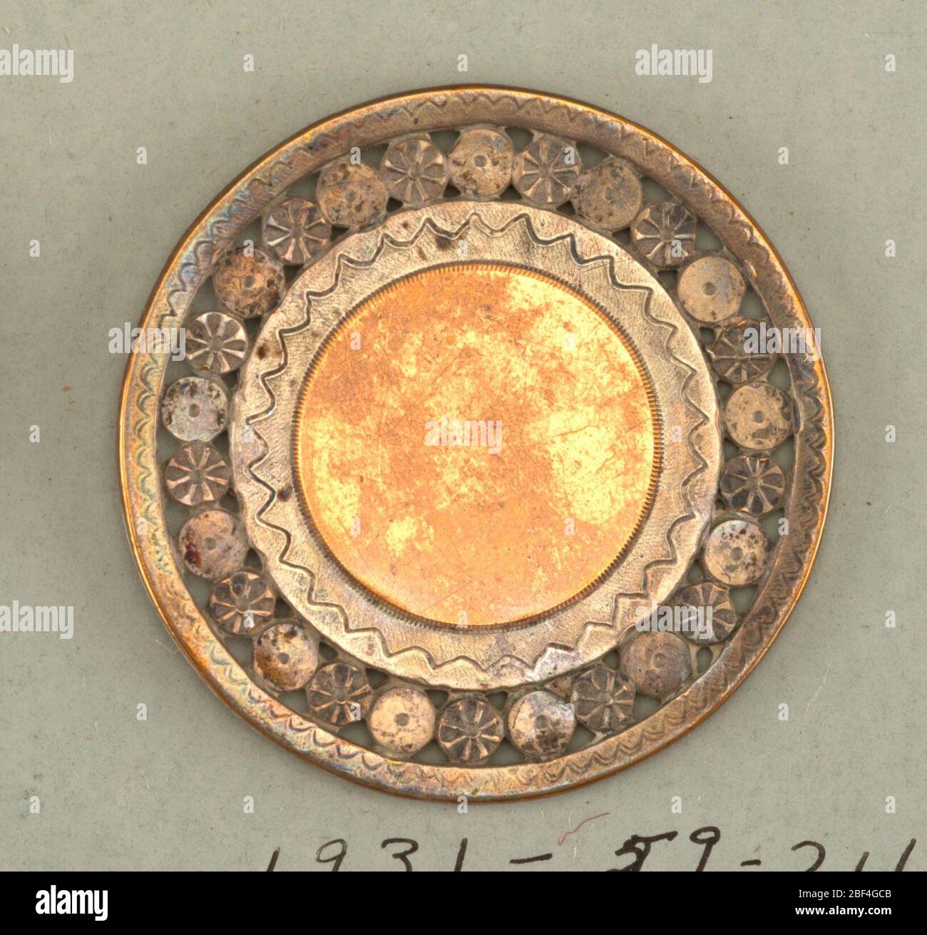 Button. A) Copper center with pierced and engraved nickel border; B ...