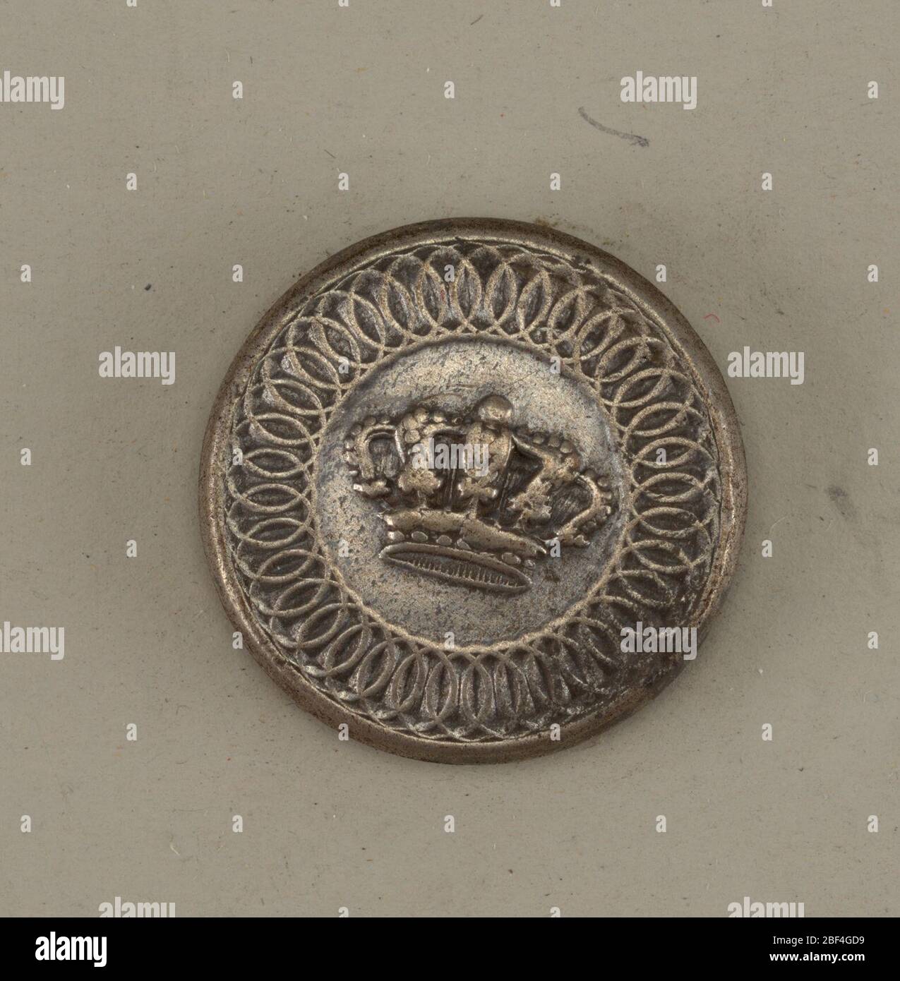 Button. Flat button ornamented in design of a crown within a border ...
