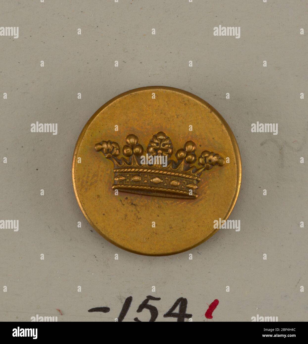 Button. Flat button ornamented with a crown. Brass back and shank. On ...