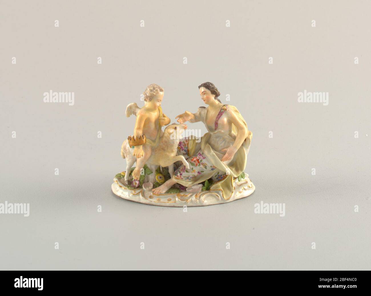 Figure of a Cherub and a Seated Lady. Figural group; a cherub with a ...