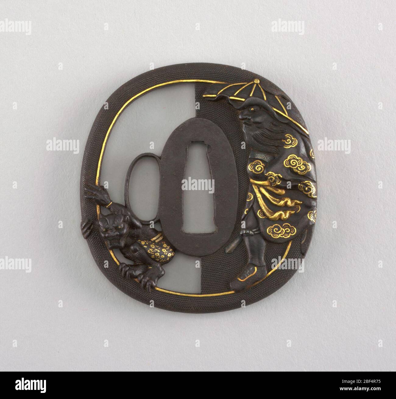 Tsuba. This iron tsuba is nade (oval) in shape and has a maru mimi ...