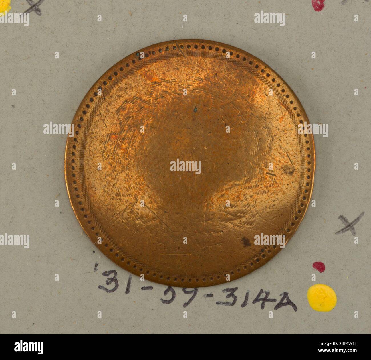 Button. circular nearly flat button with engraving at the edge and an ...