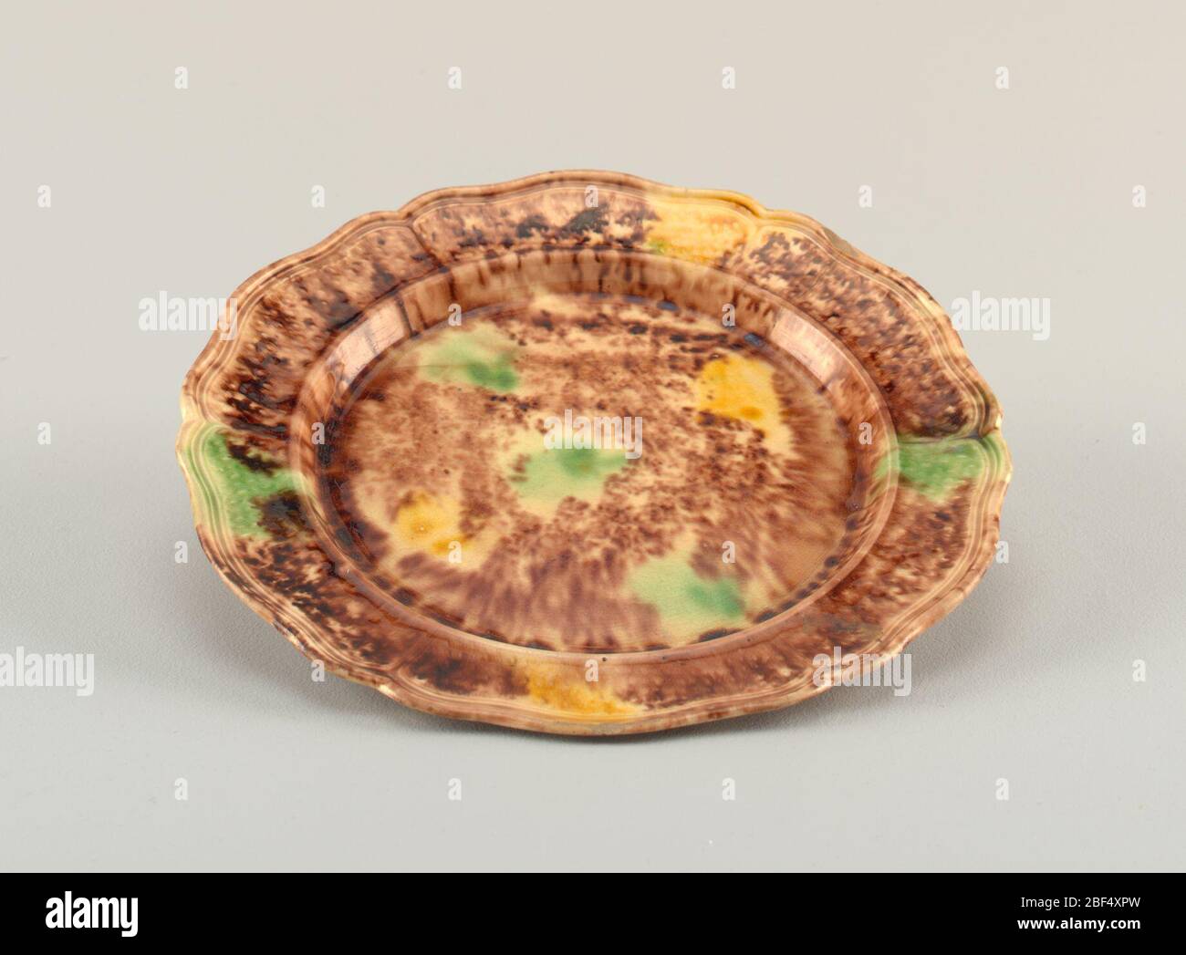 Plate. Molded edge; marly decorated with wavy lines enclosing lozenges ...