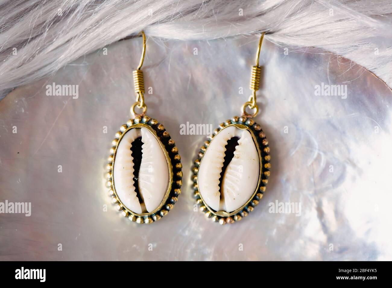 Earrings with sea shells in brass decorative oval frame Stock Photo - Alamy