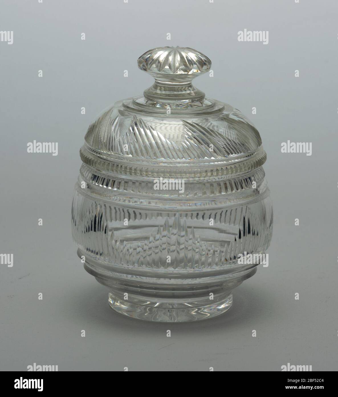 Jar and lid. Round body cut with vertical flutes in graduated lengths ...