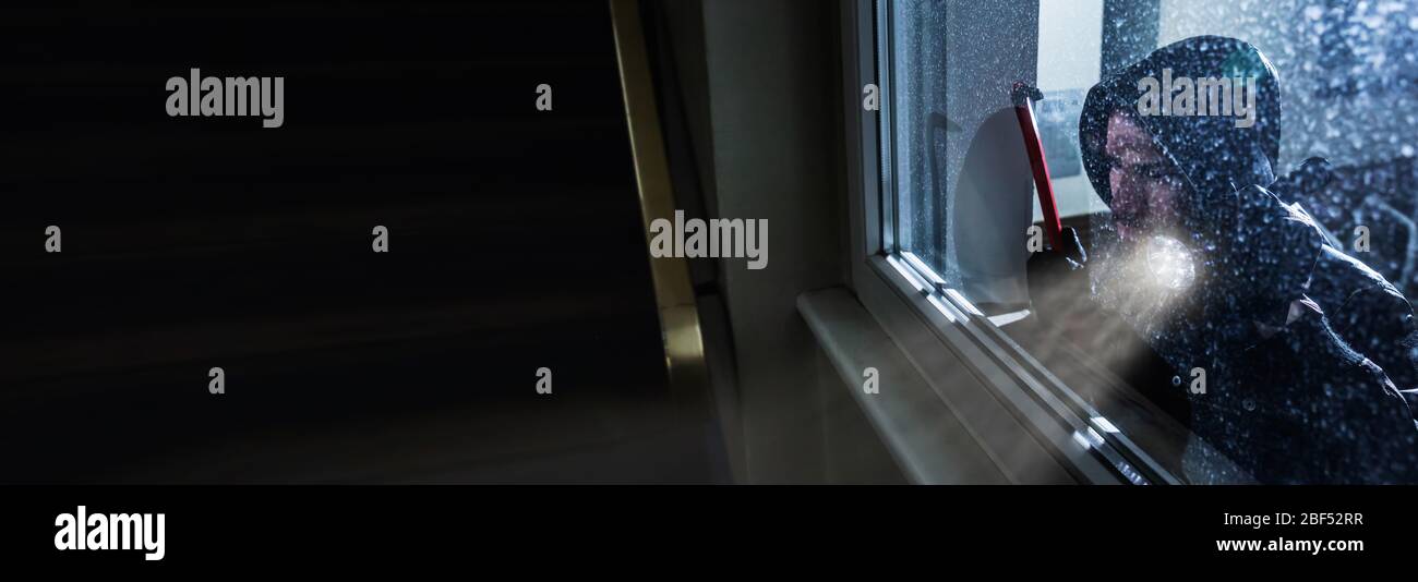 Thief Breaking House Window To Enter House Stock Photo - Alamy