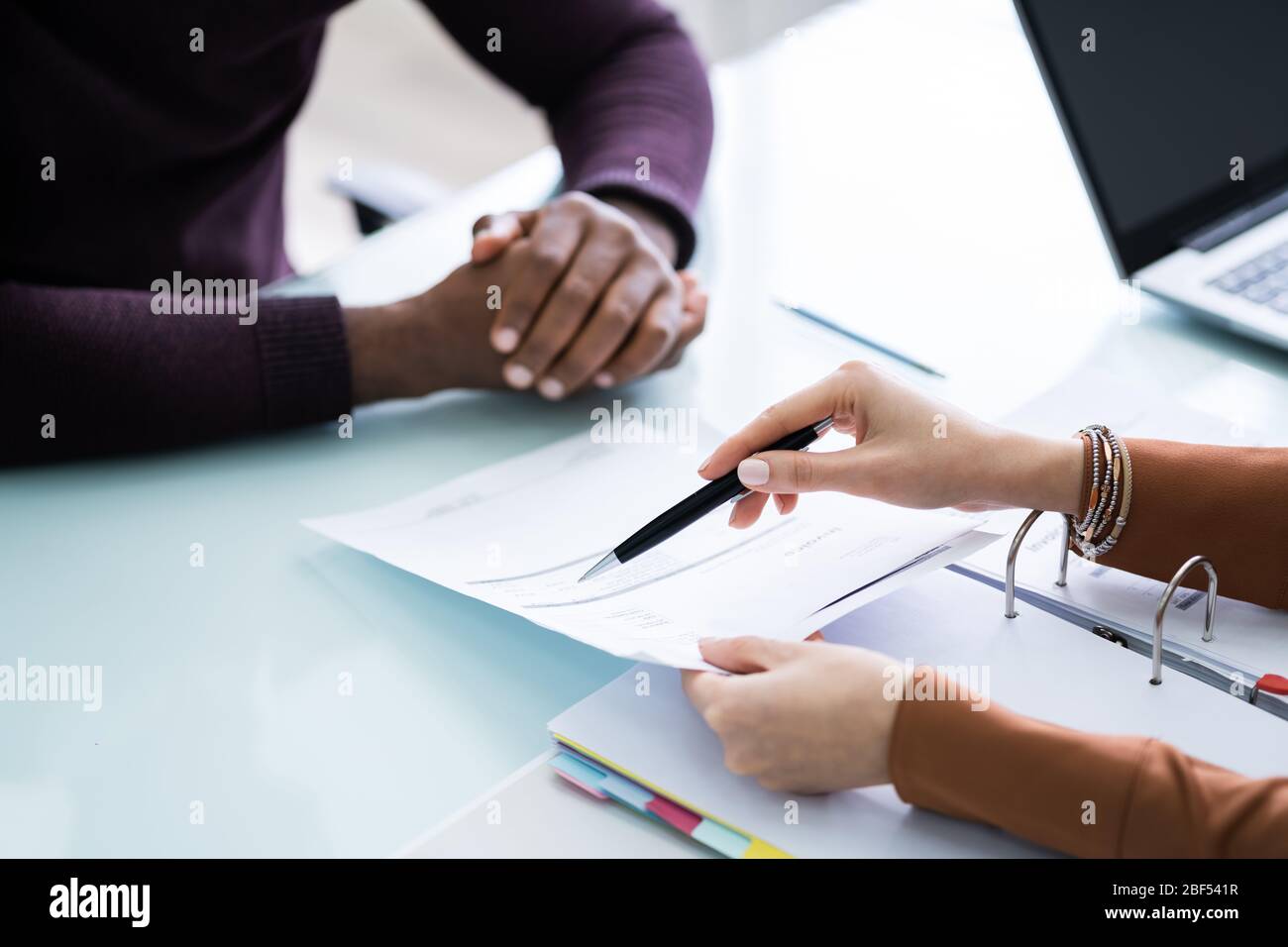 Young Financial Advisor Discussing Invoice With Her Client At Workplace ...