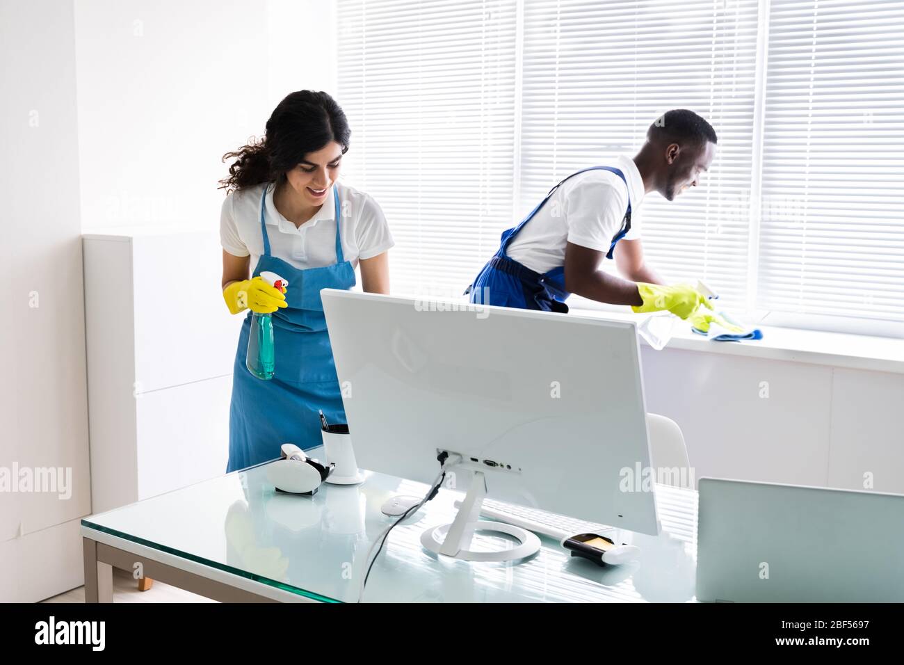 Young Male And Female Cleaners Cleaning Office Stock Photo - Alamy