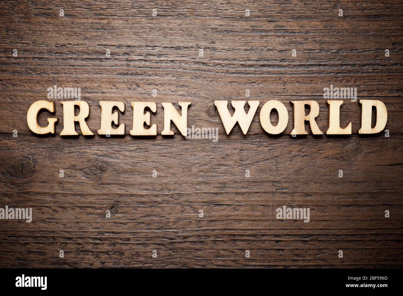 Green world text on a wood table Stock Photo - Alamy
