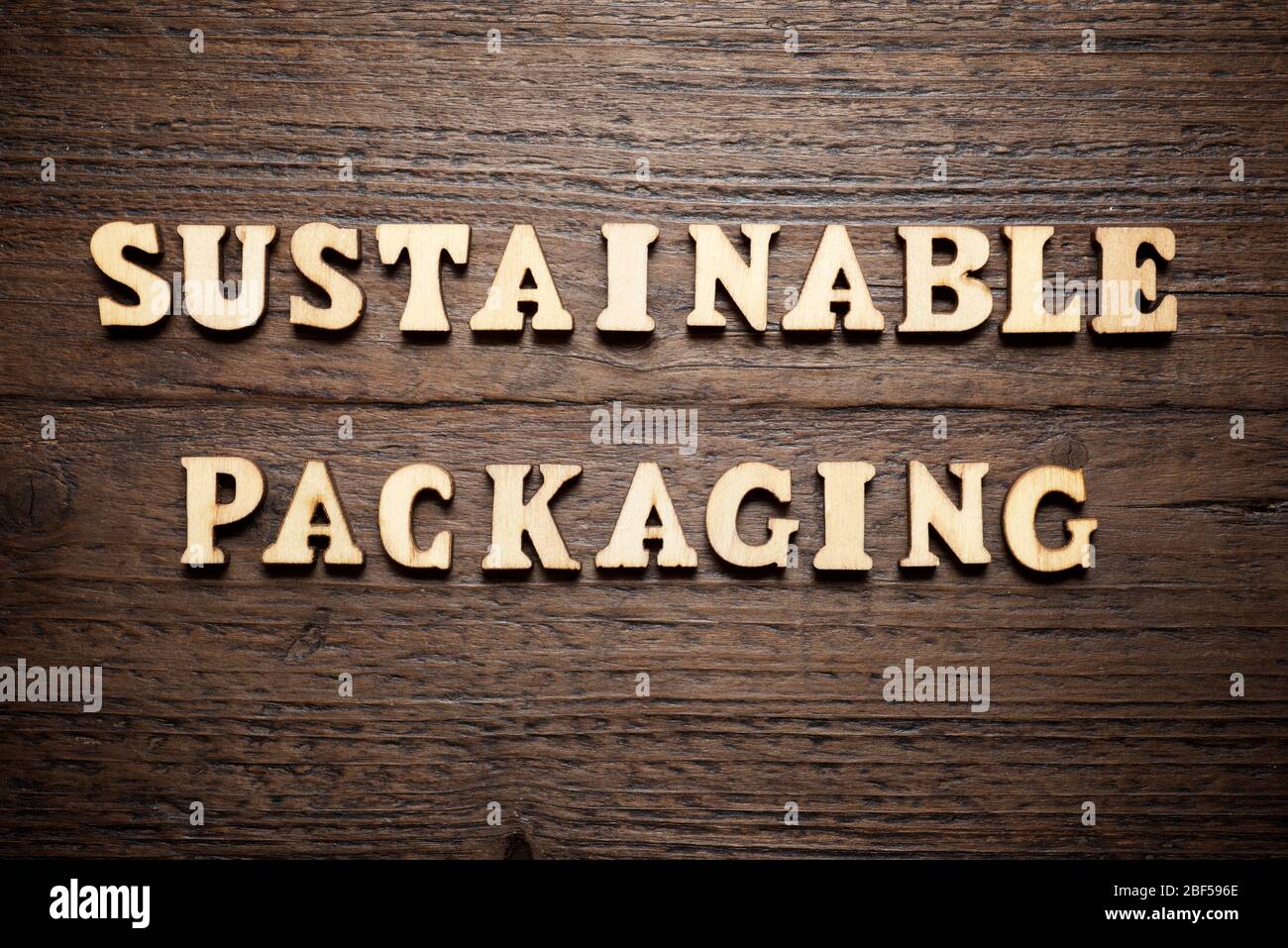 Sustainable packaging text on a wood table Stock Photo - Alamy