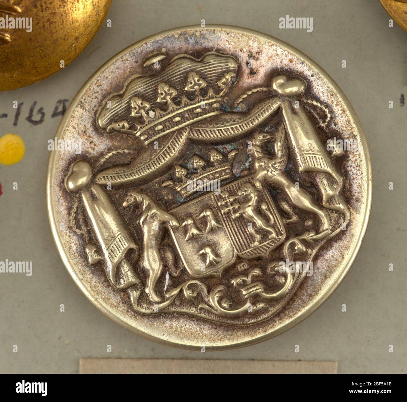 Button. Circular flat button with coat of arms with two shields with ...