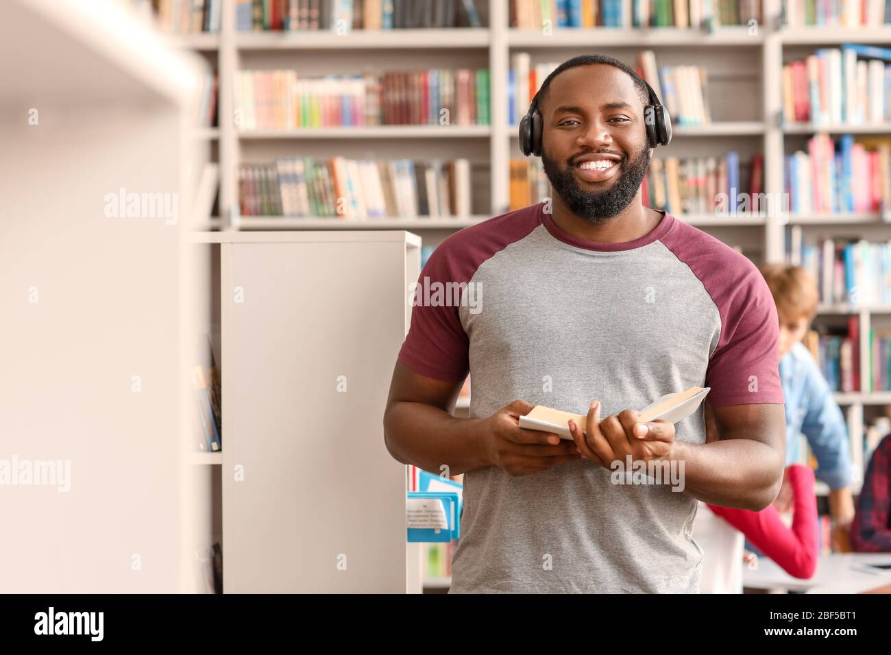 African-American student reading book while preparing for exam in ...
