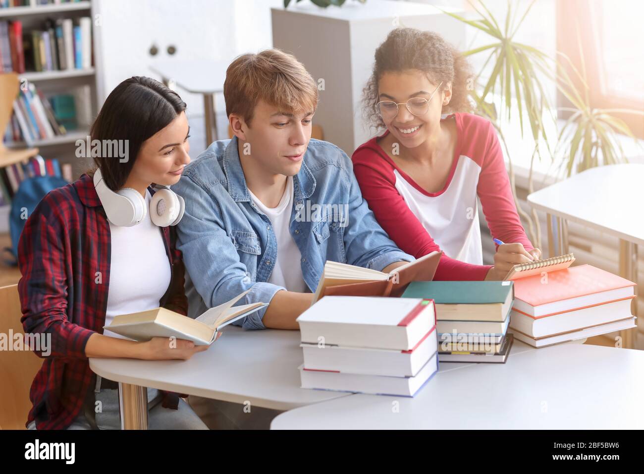 Young students reading books while preparing for exam in library Stock ...