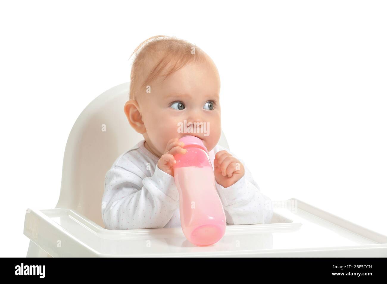 Baby with bottle of milk sitting in high-chair on white background ...