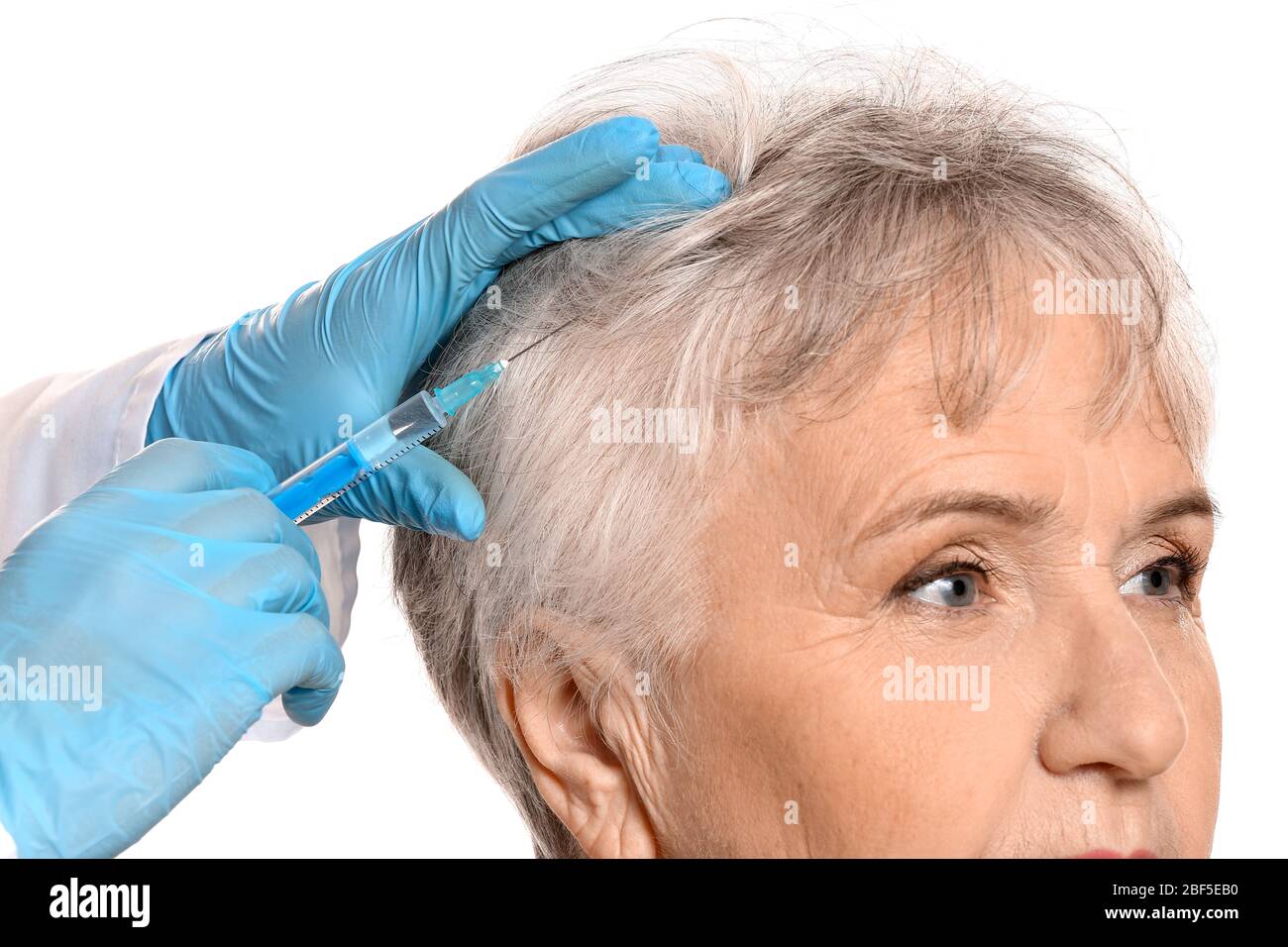 Senior woman with hair loss problem receiving injection on white ...