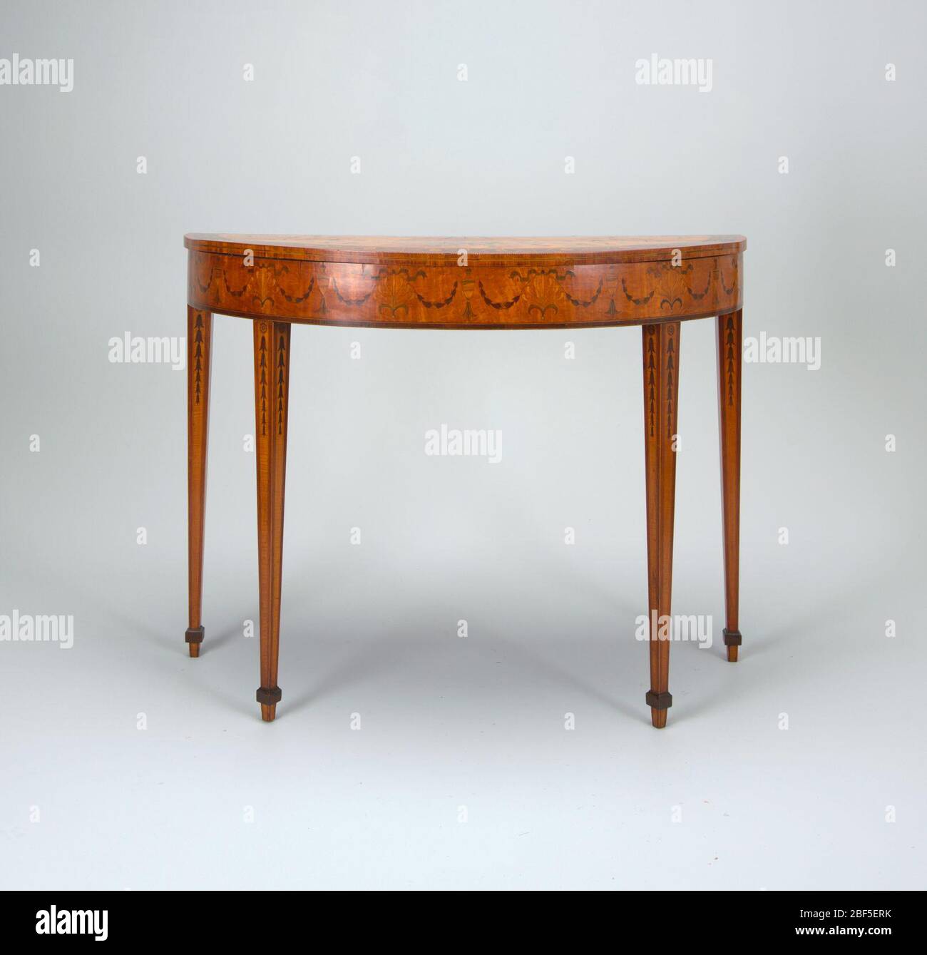 Half table. A light wood half table with scalloped edges sitting on ...