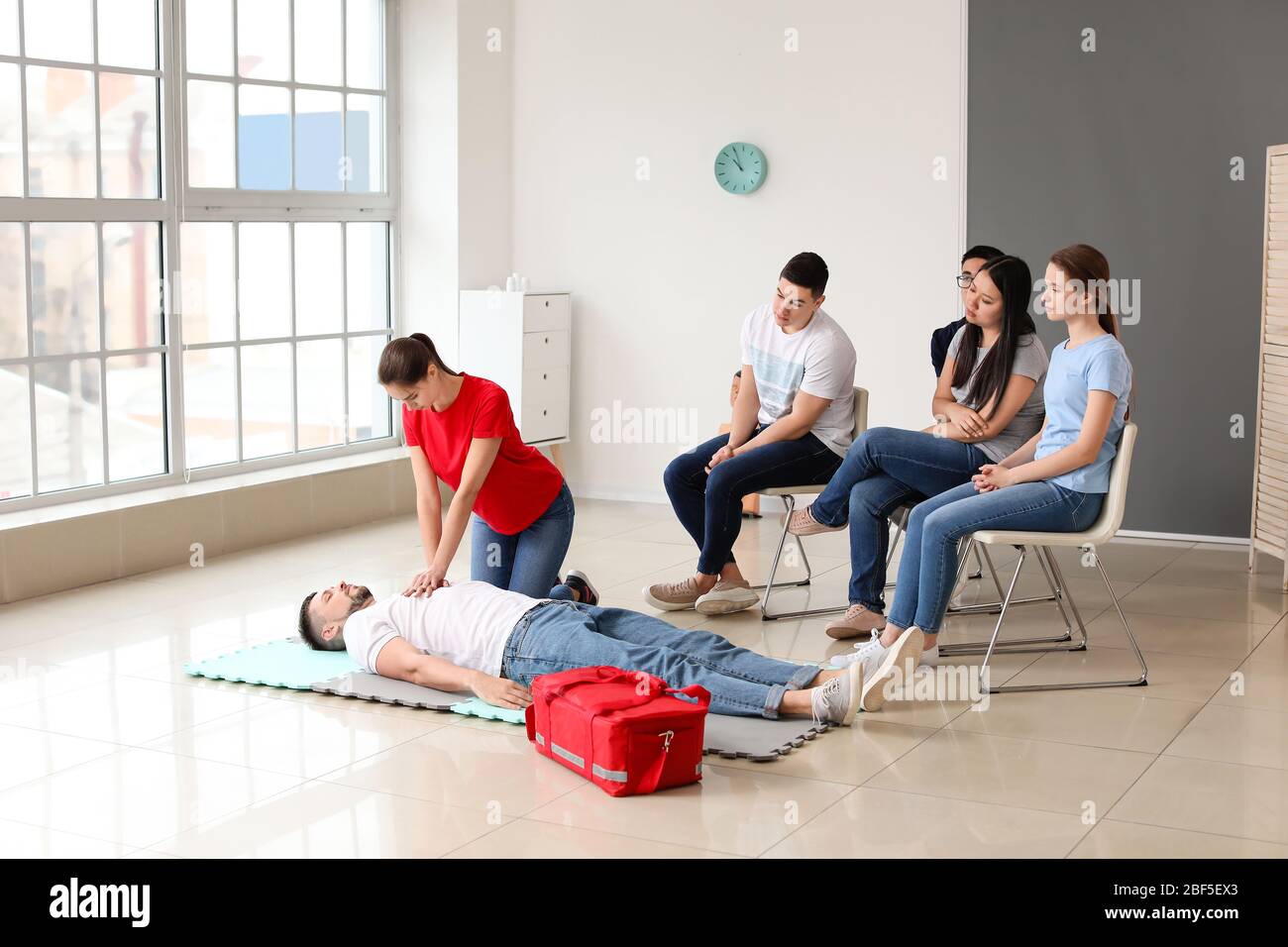 Instructor demonstrating CPR on man at first aid training course Stock ...