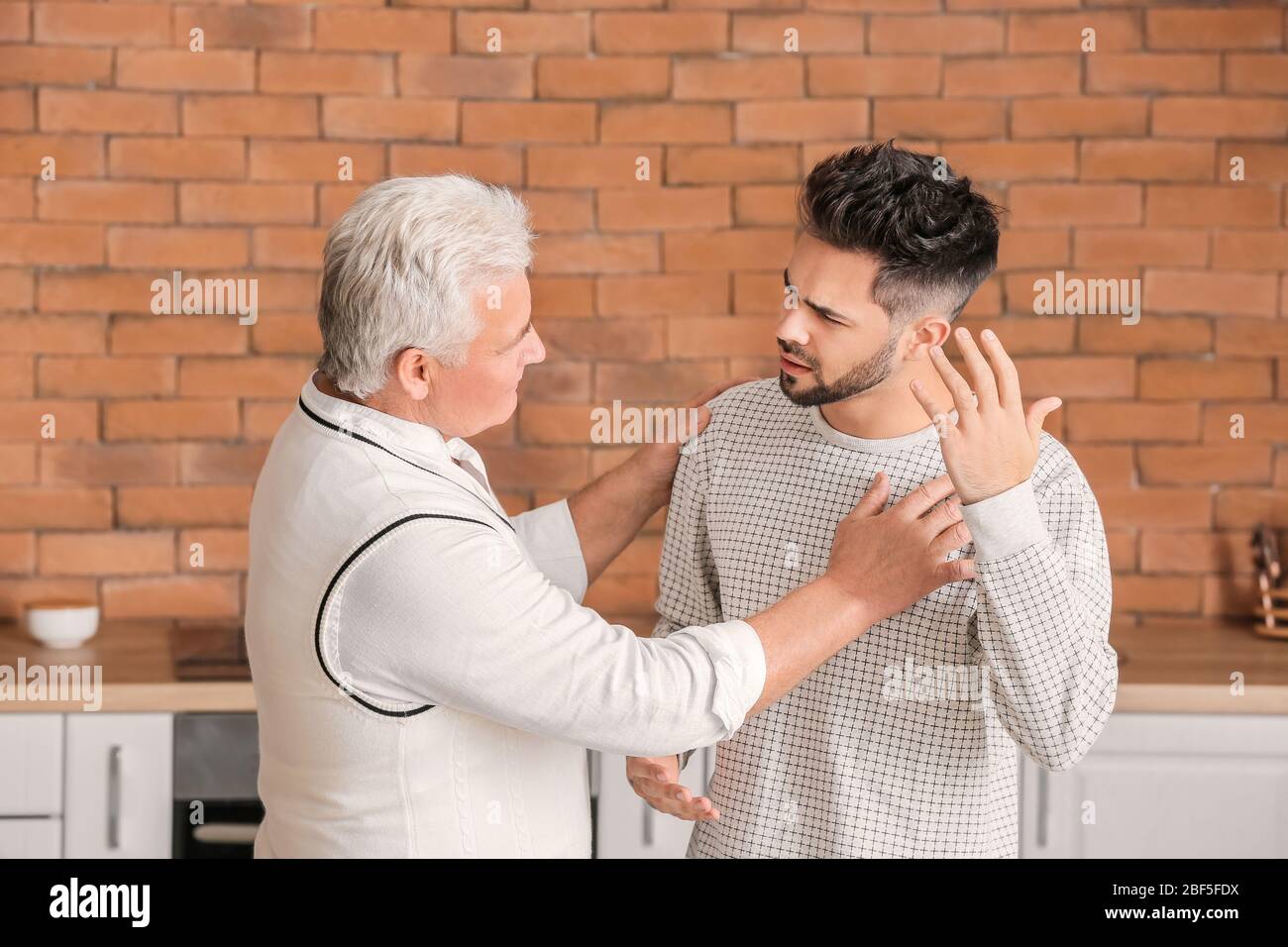 Young man and his father arguing in kitchen Stock Photo - Alamy