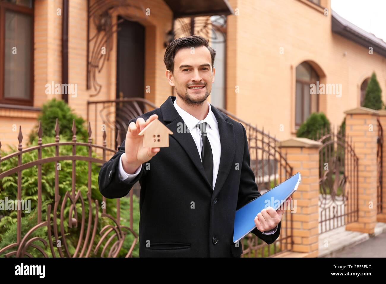 Male real estate agent near house for sale outdoors Stock Photo - Alamy