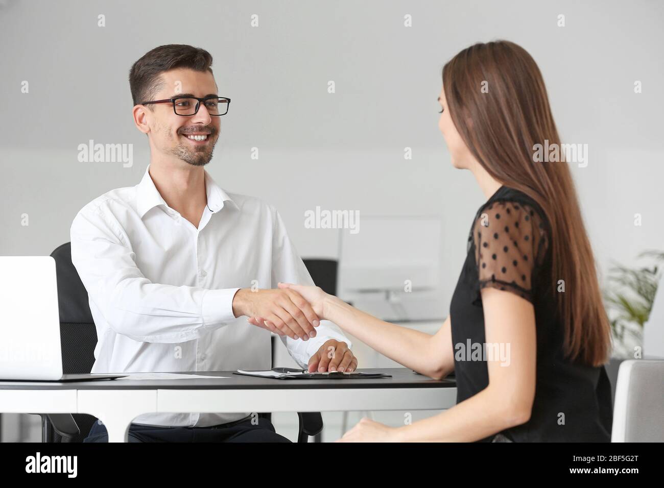 Bank manager shaking hands with woman in office Stock Photo - Alamy