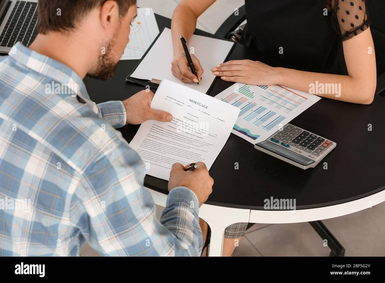 Couple signing a loan contract in bank Stock Photo - Alamy