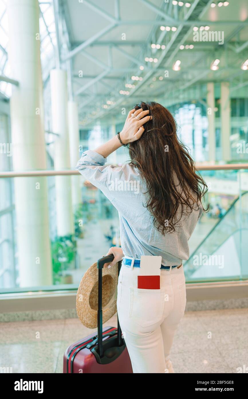 Young woman in hat with baggage in international airport walking with ...