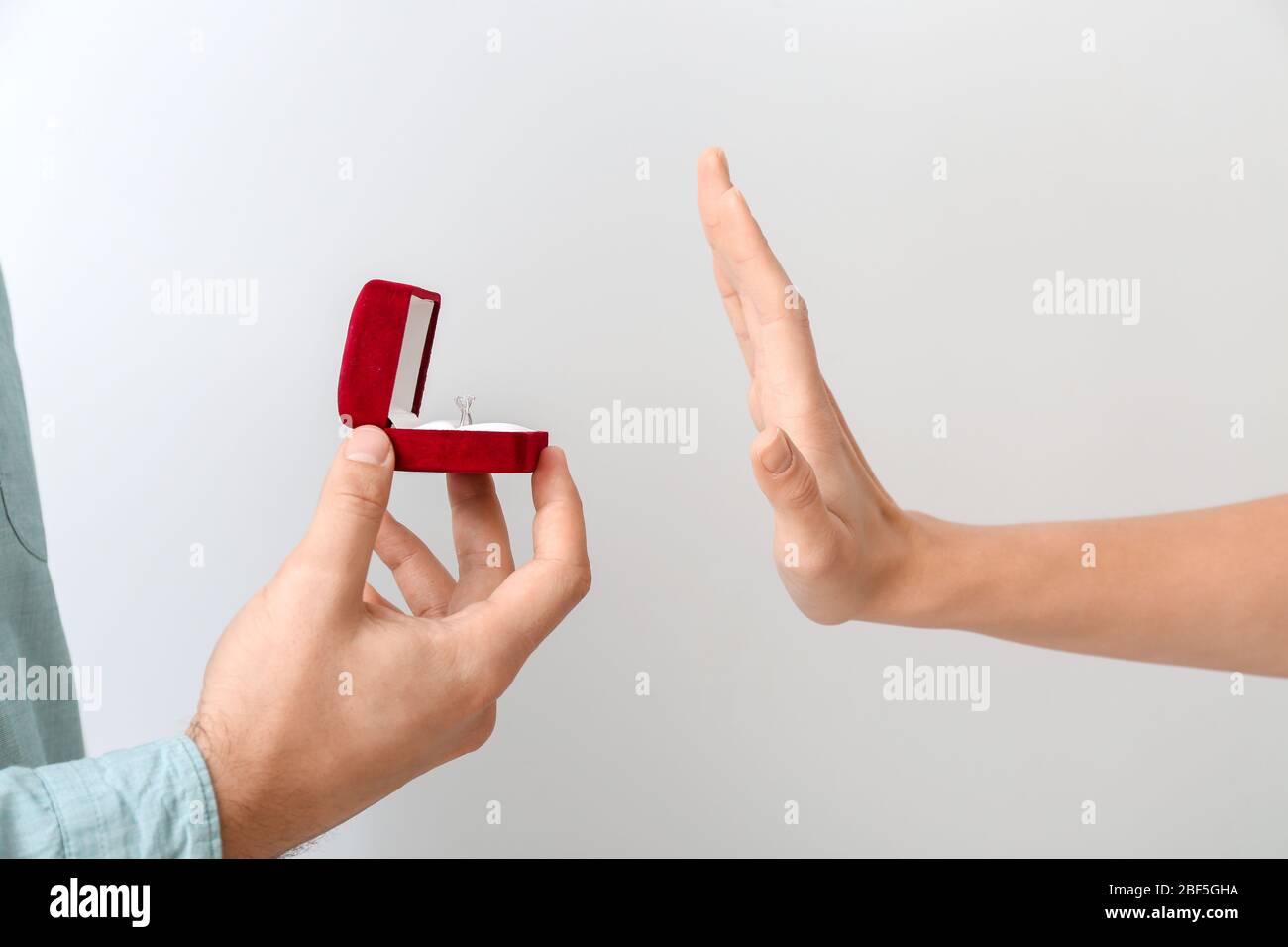 Young woman rejecting marriage proposal on light background Stock Photo ...