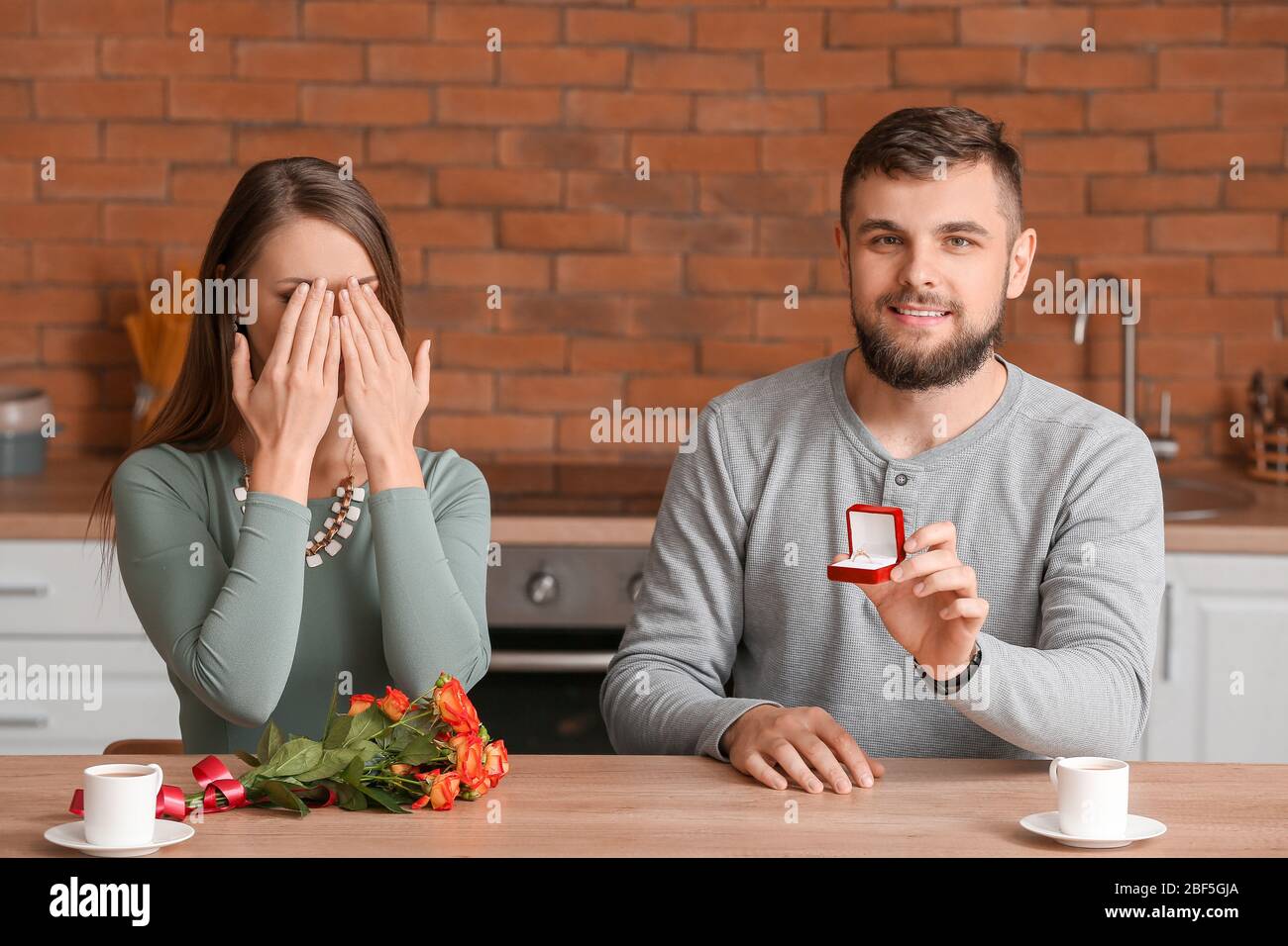 Young man proposing to his beloved at home Stock Photo - Alamy