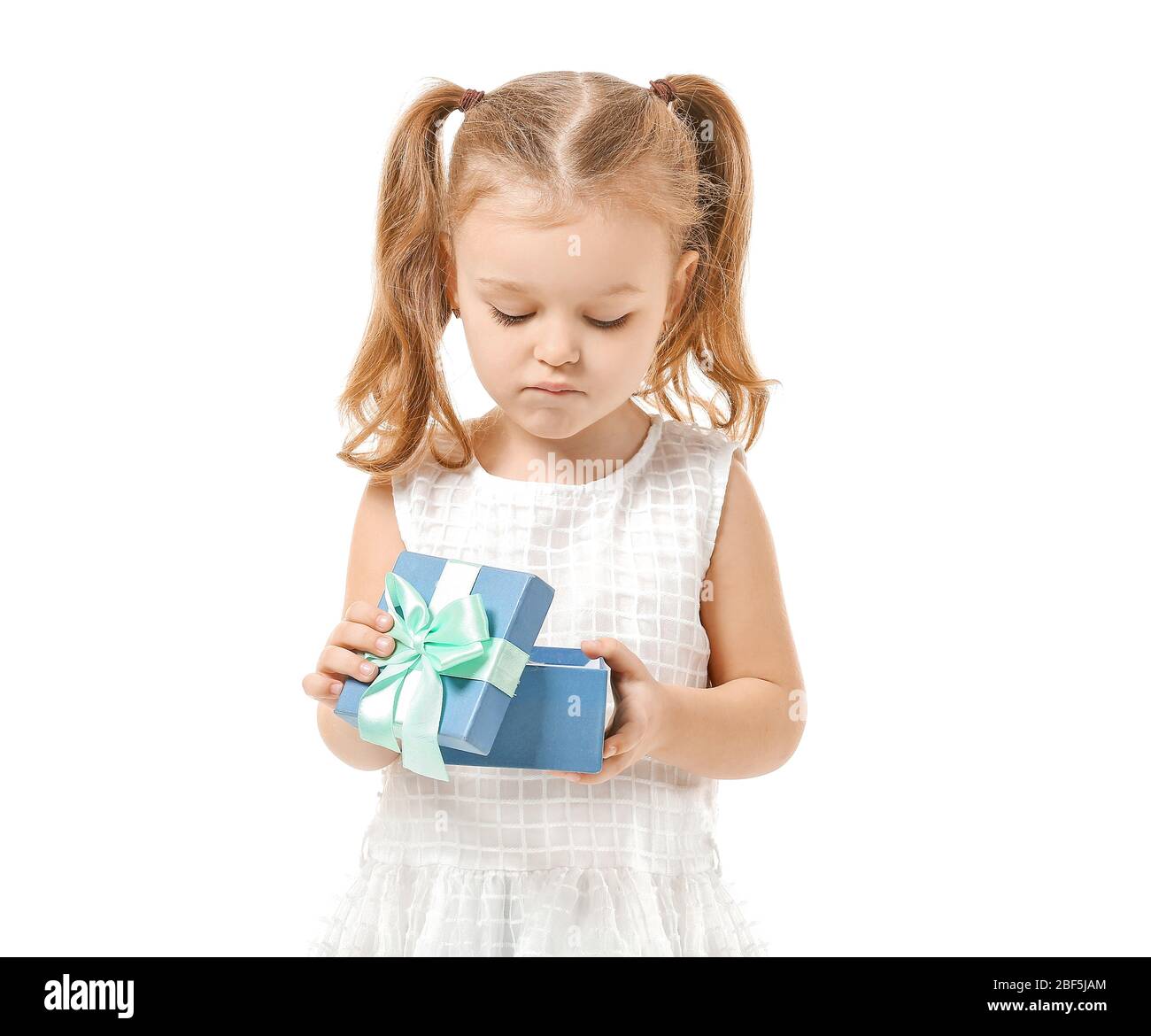 Sad little girl with gift on white background Stock Photo - Alamy