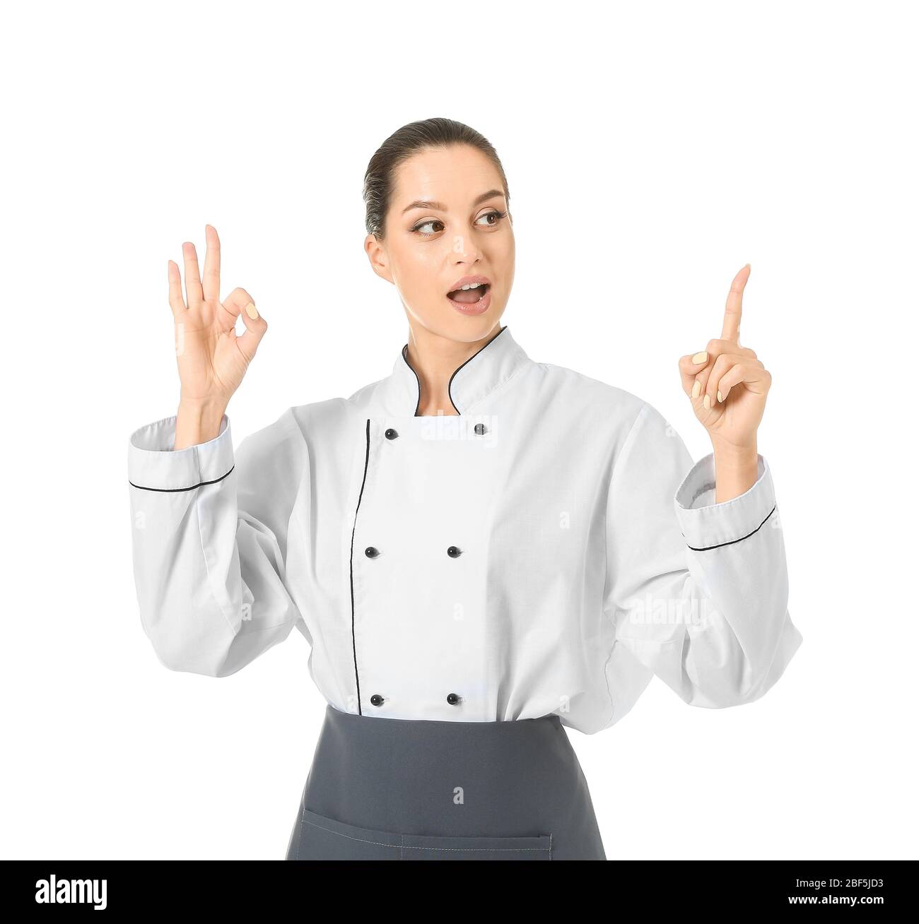 Beautiful female chef with raised index finger showing OK on white ...