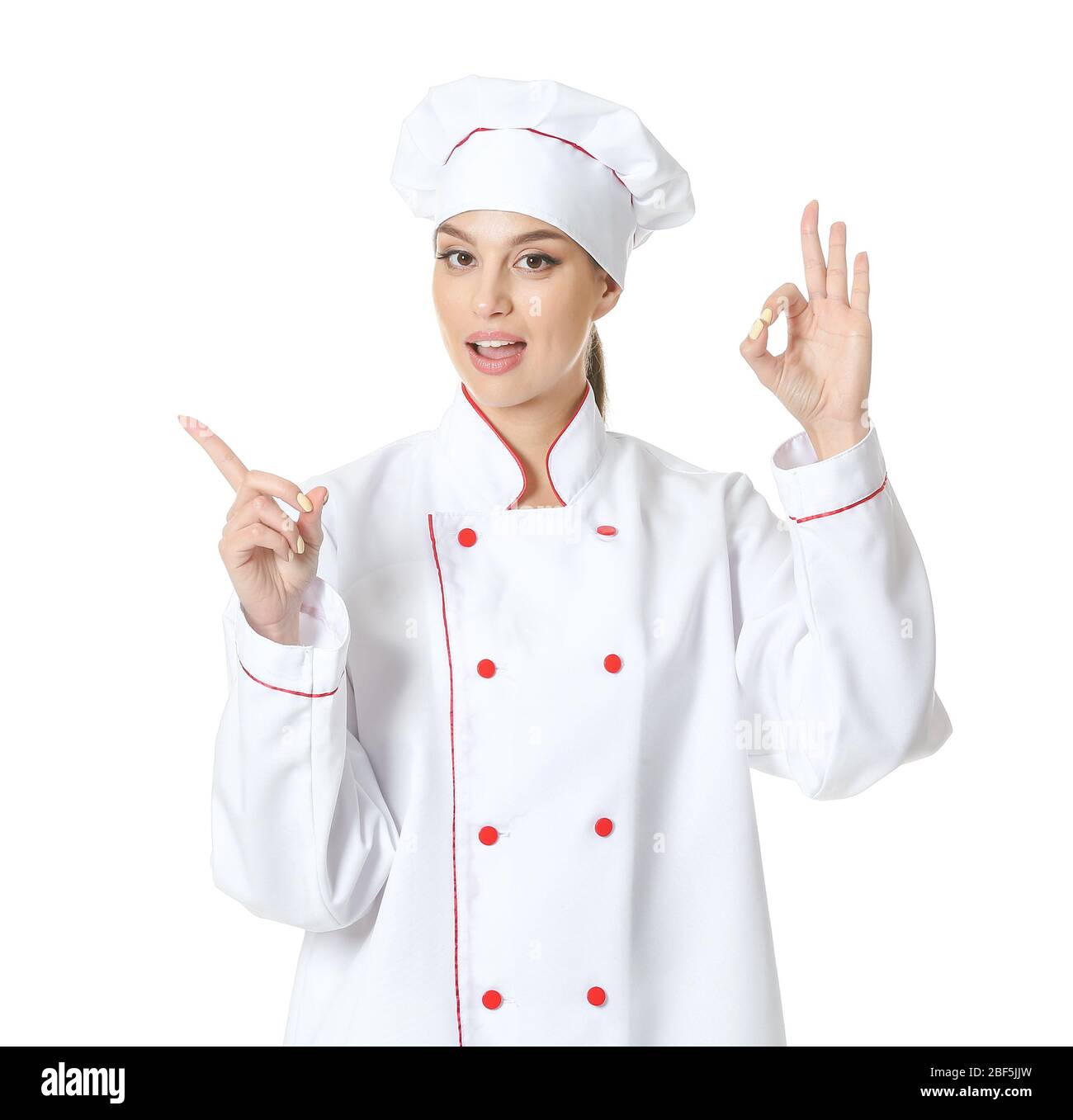 Beautiful female chef pointing at something on white background Stock ...