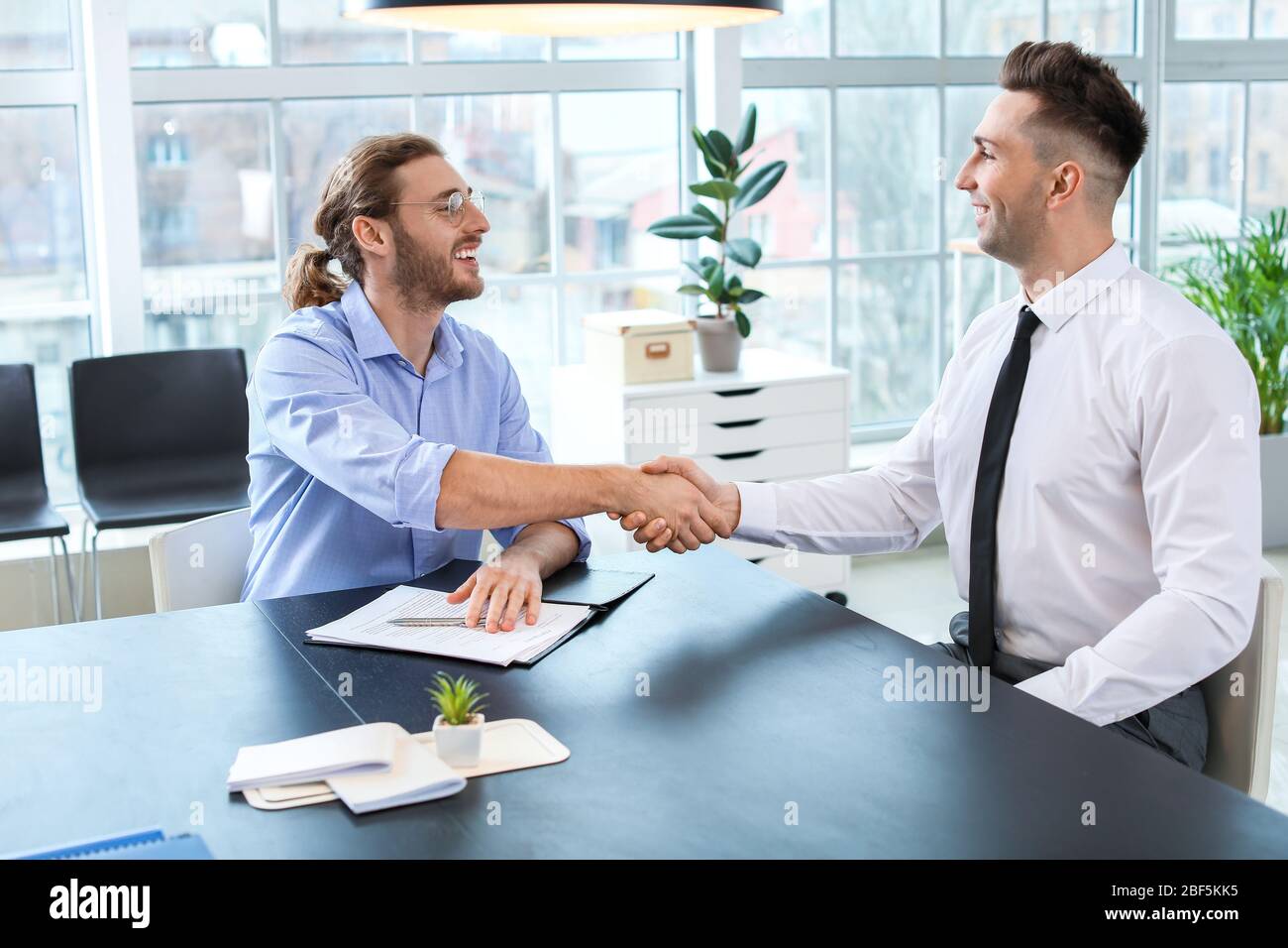 Human resources manager shaking hands with applicant after successful ...
