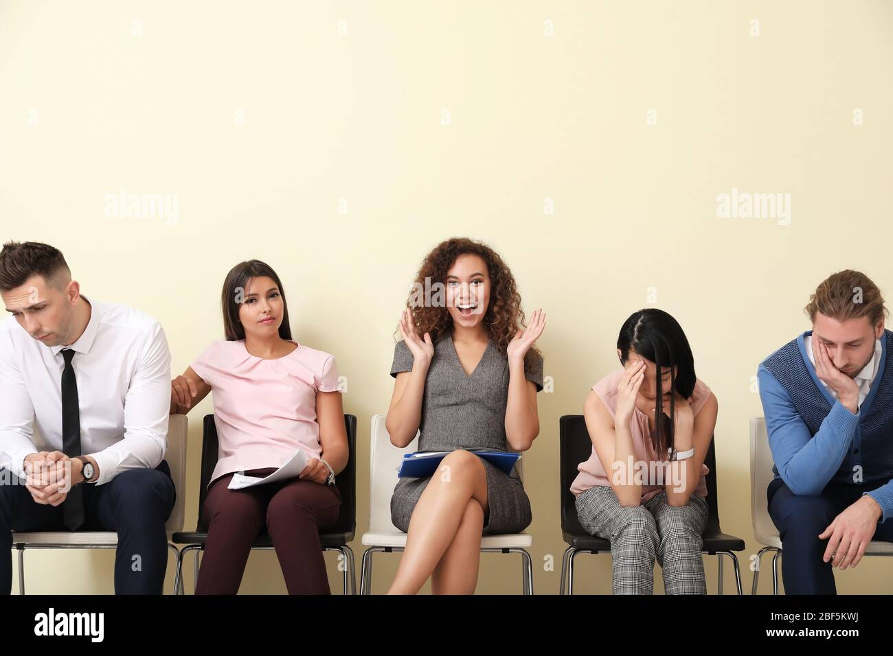 Sad people and happy African-American woman after job interview Stock ...