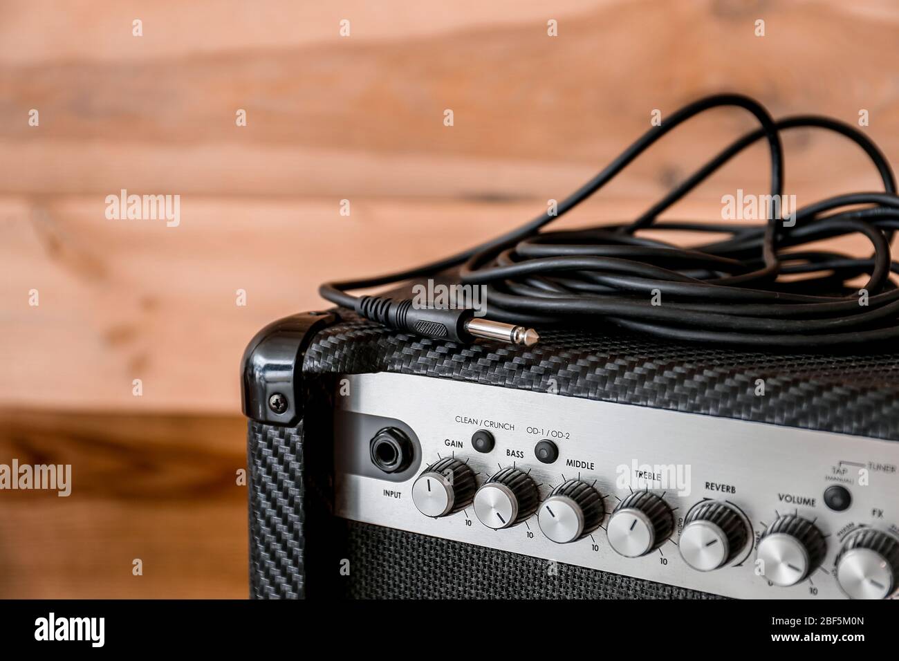 Modern amplifier near wooden wall, closeup Stock Photo - Alamy
