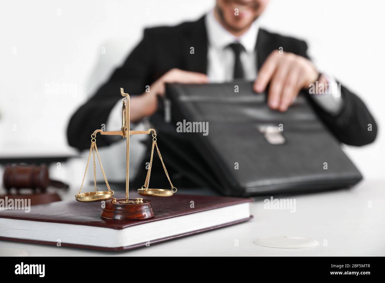 Scales with law book on table of notary public in office Stock Photo ...