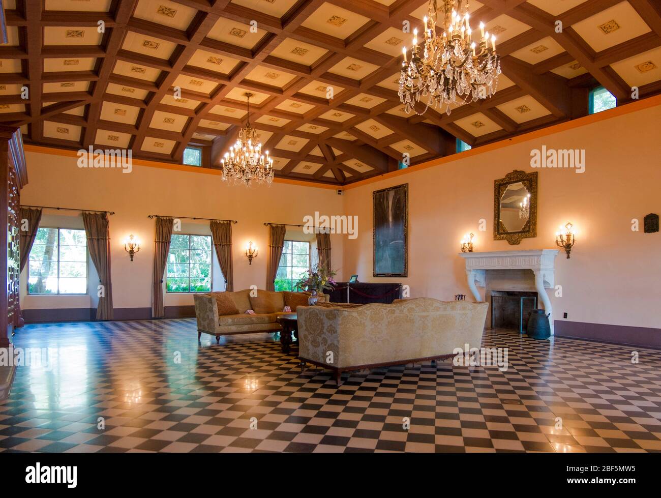 A view of the living room with fireplace in the stone mansion. At the ...