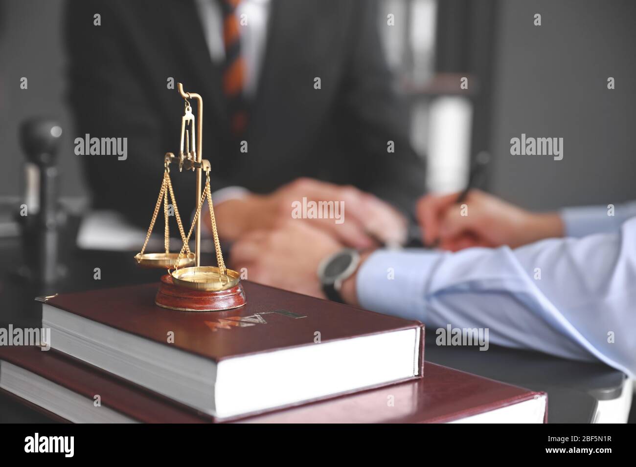 Scales of justice with law books on table of notary public in office ...